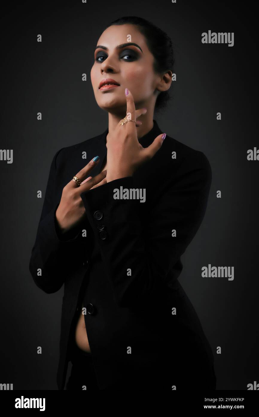 A stunning solo image of a tall female model in a classic black suit ...