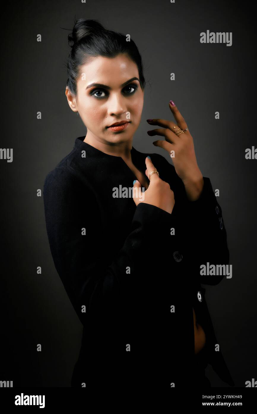 A stunning solo image of a tall female model in a classic black suit ...