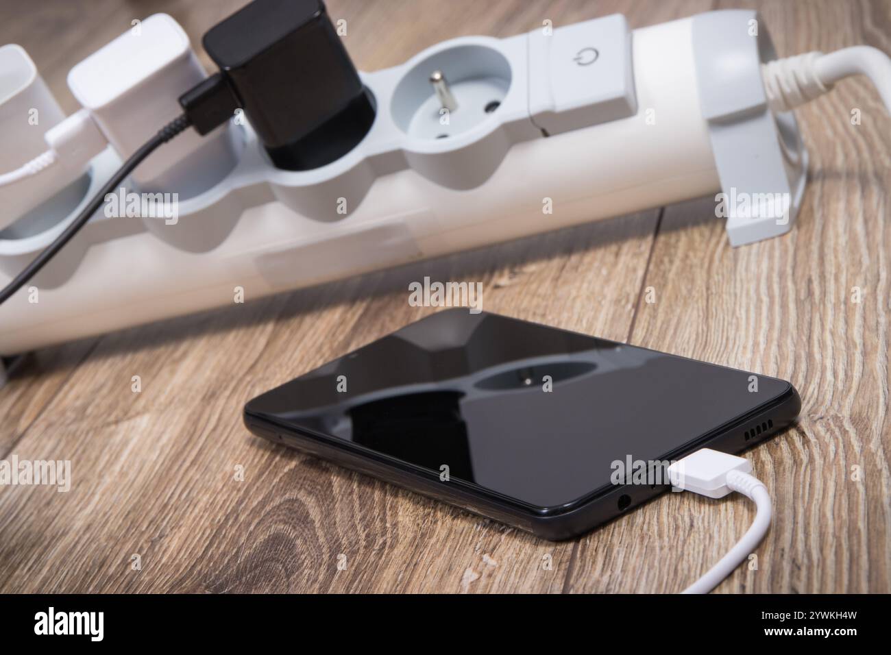 Smartphone, mobile phone and chargers connected to electrical power ...