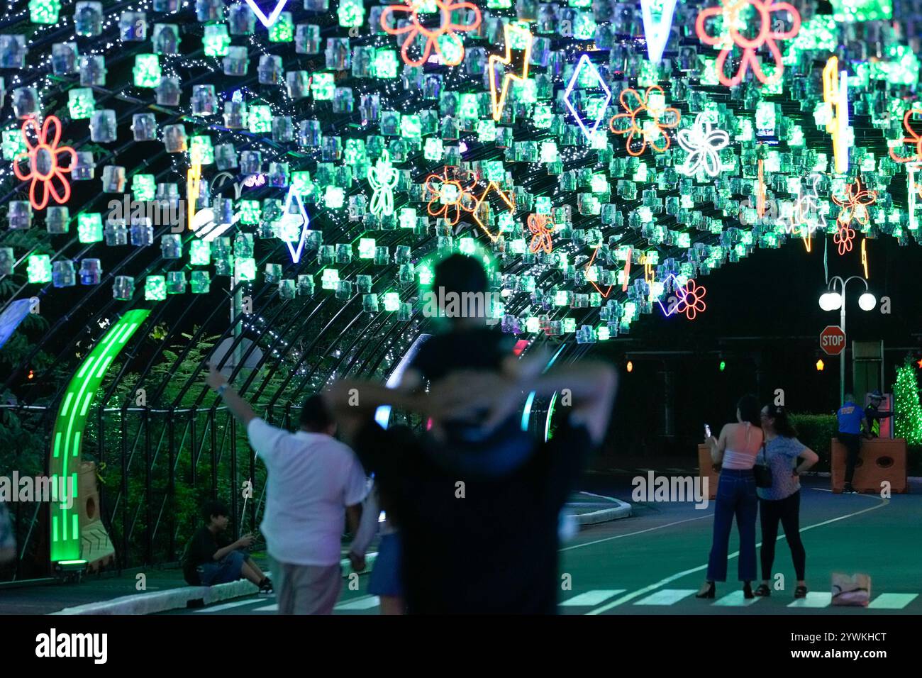 Visitors walk under a Christmas display at the Meralco Liwanag Park in ...