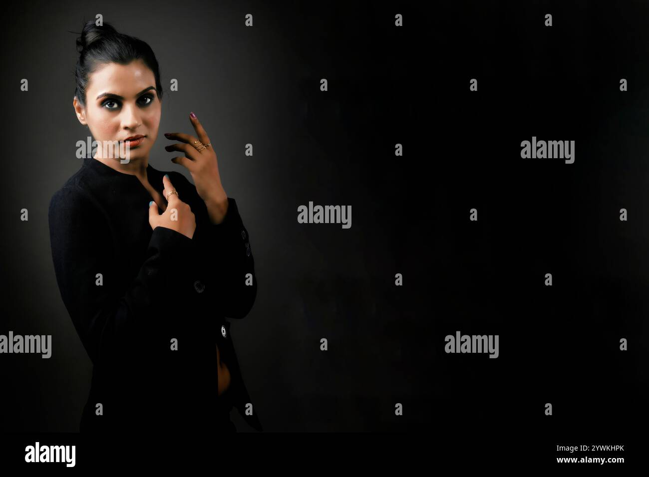 A stunning solo image of a tall female model in a classic black suit ...