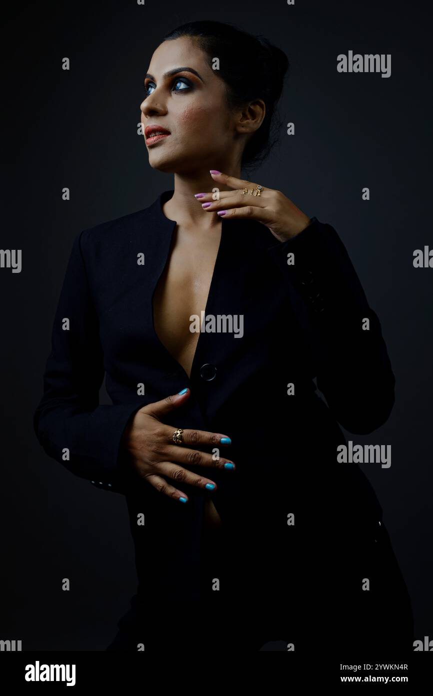 A stunning solo image of a tall female model in a classic black suit ...