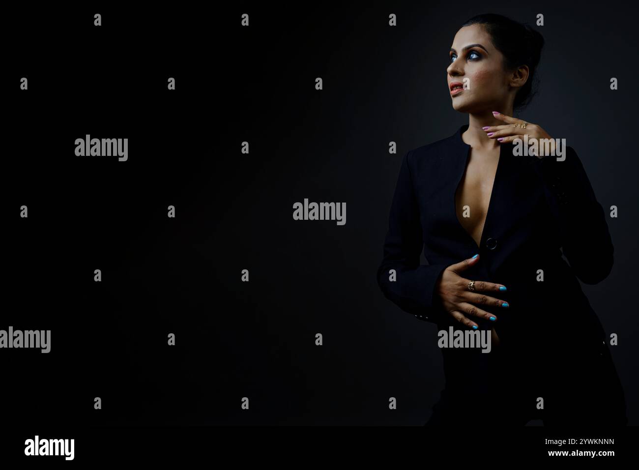 A stunning solo image of a tall female model in a classic black suit ...