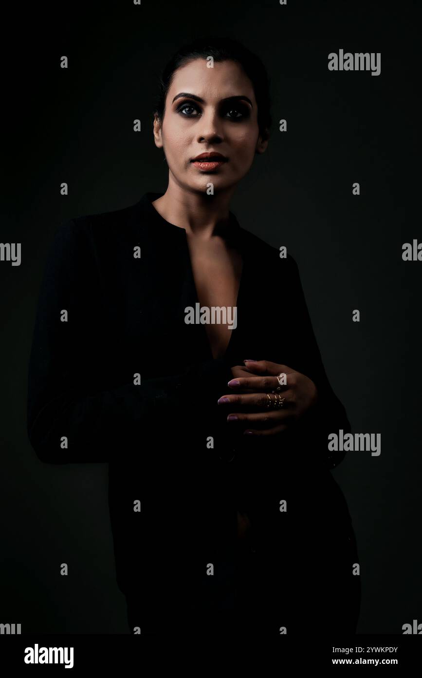 A stunning solo image of a tall female model in a classic black suit ...