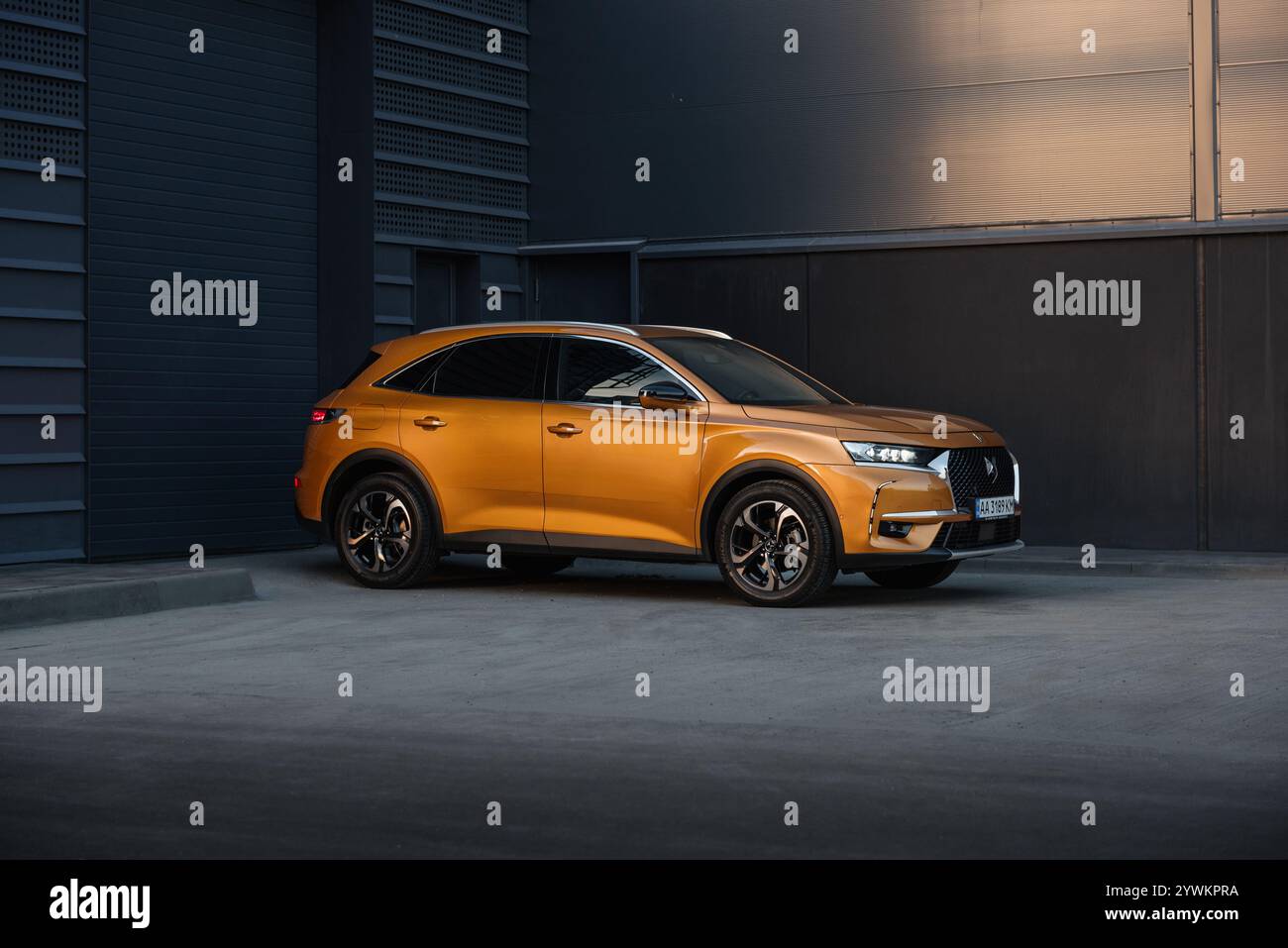 Light brown DS7 parked near dark grey warehouse at sunset. Three ...