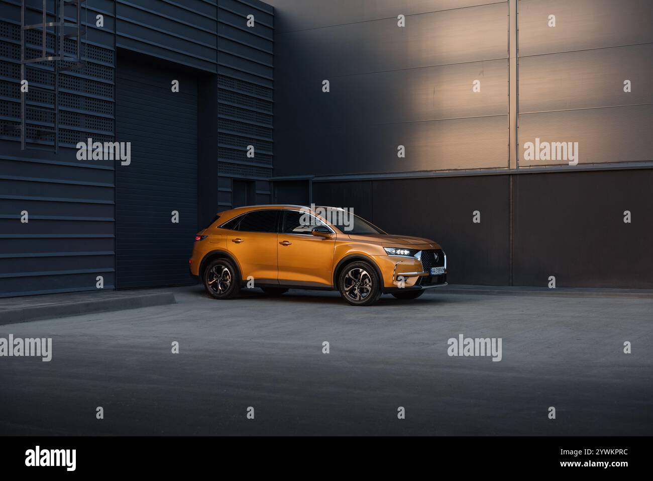 Light brown DS7 parked near dark grey warehouse at sunset. Three ...