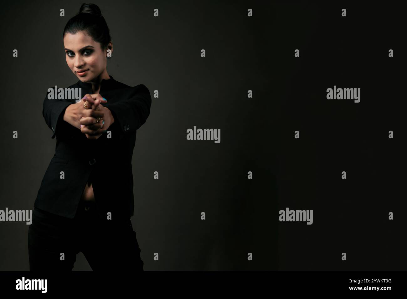 A stunning solo image of a tall female model in a classic black suit ...