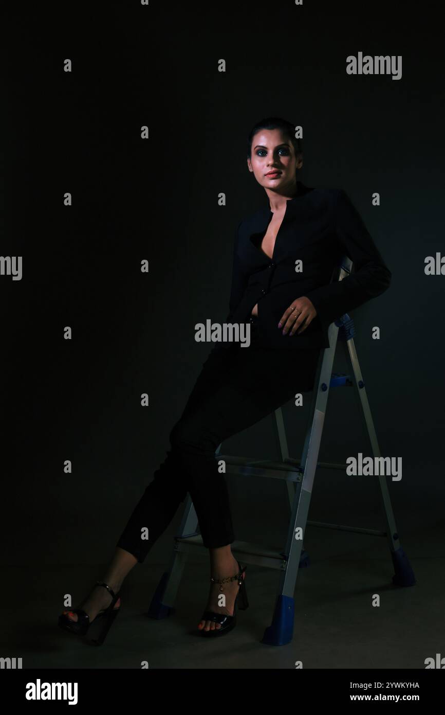 A stunning solo image of a tall female model in a classic black suit ...