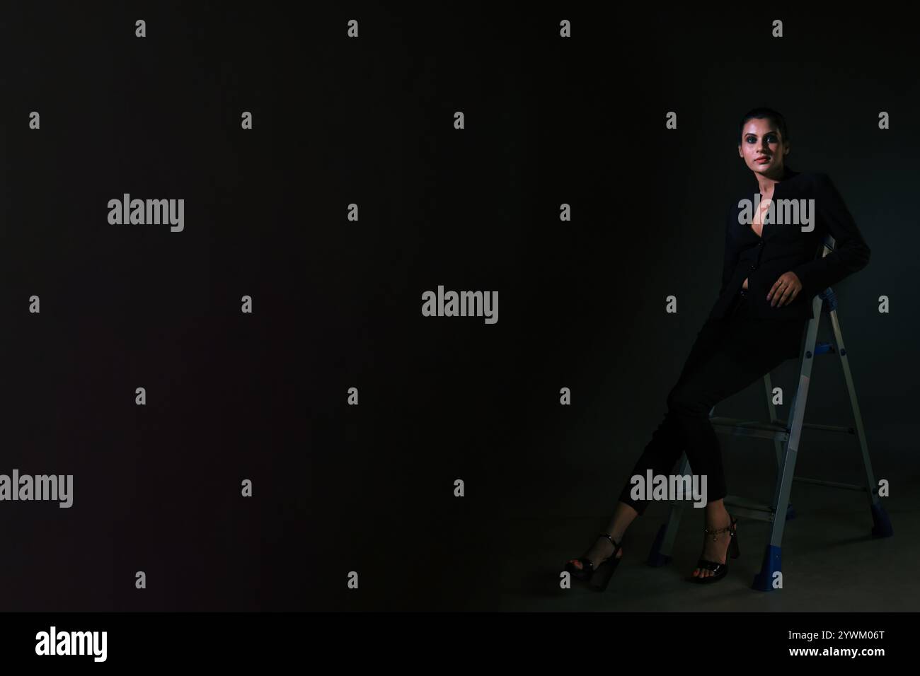 A stunning solo image of a tall female model in a classic black suit ...