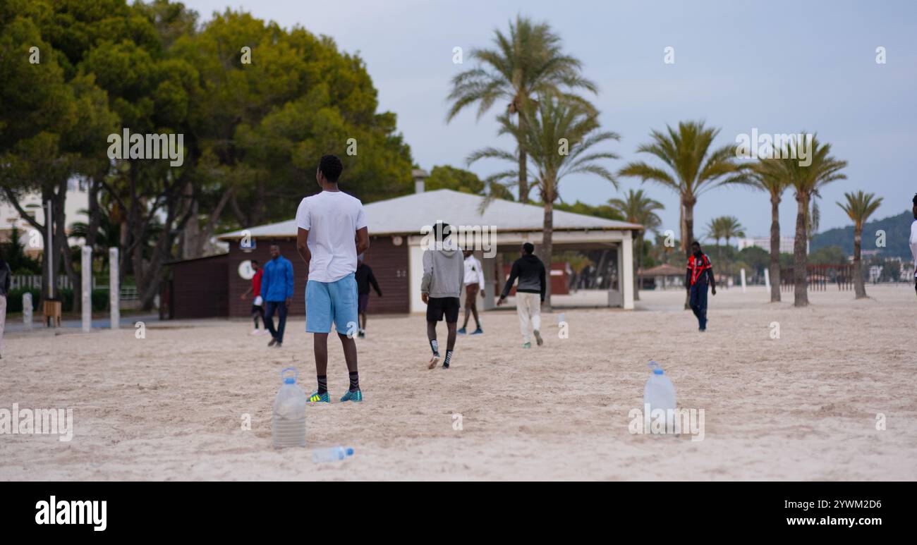 Young African American guys playing football on the beach. Beach ...