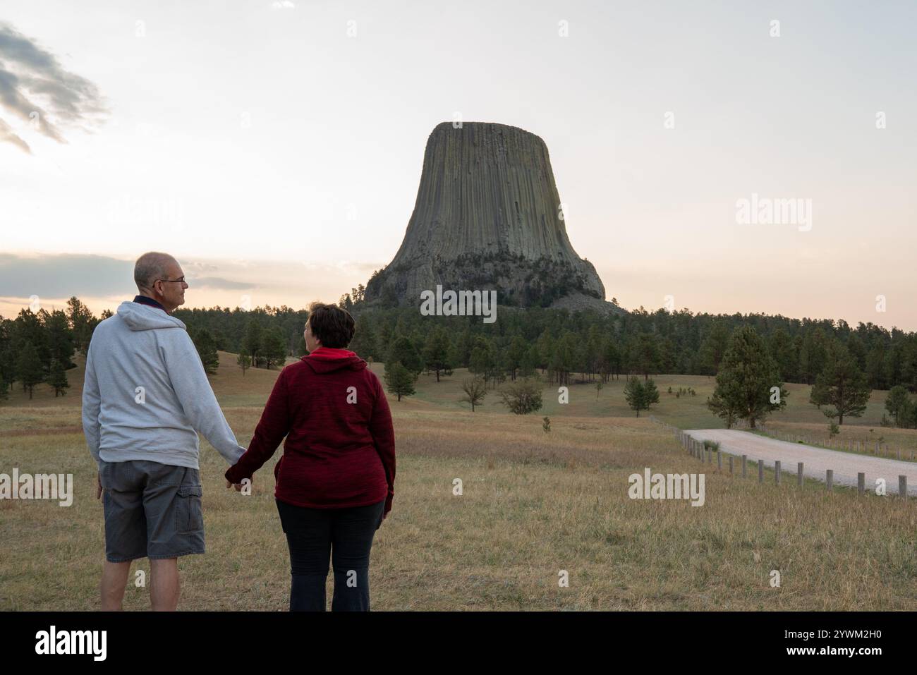 An active retired couple stand with backs to the camera looking at ...