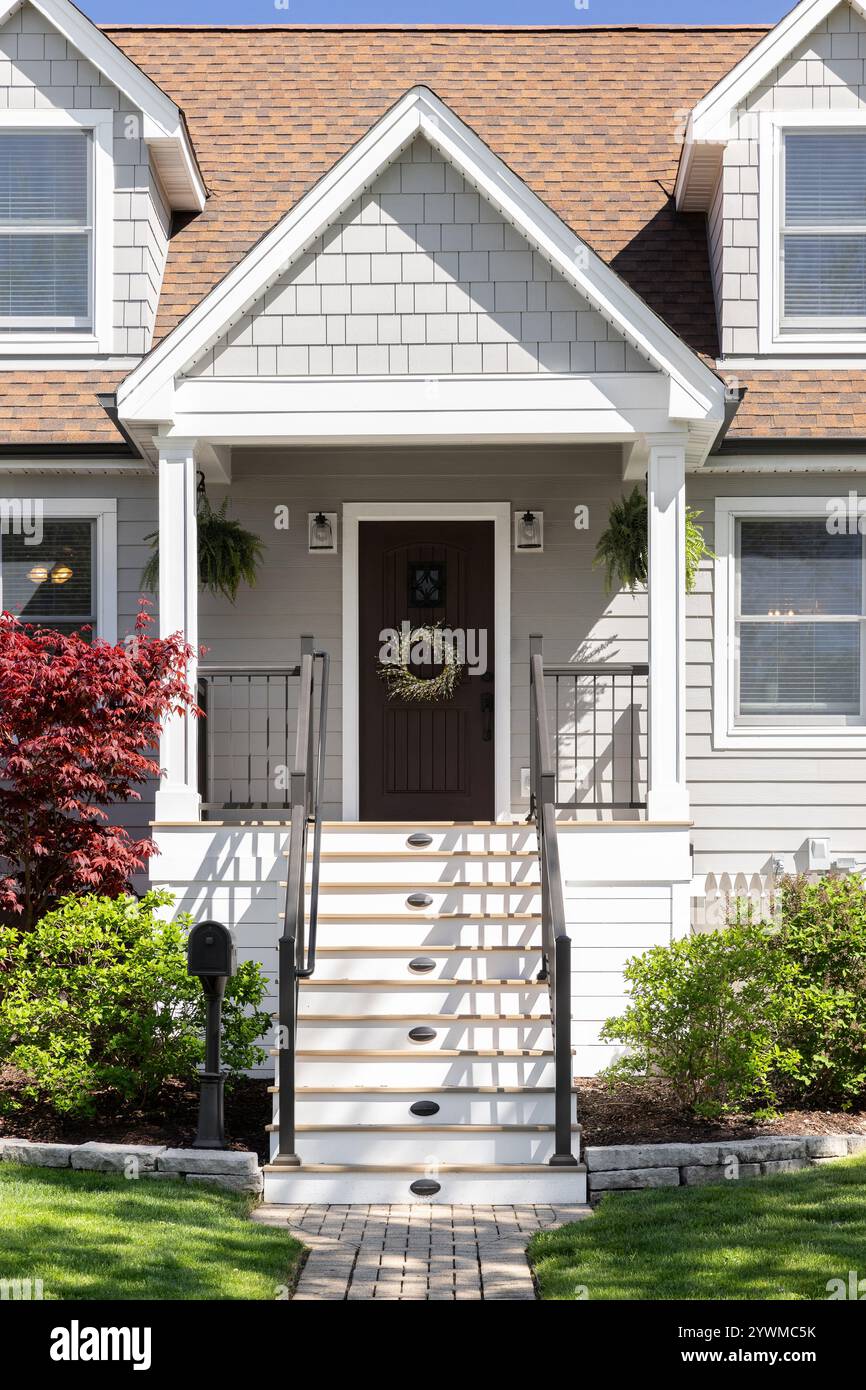 A front door detail with stairs leading to a dark wood front door ...