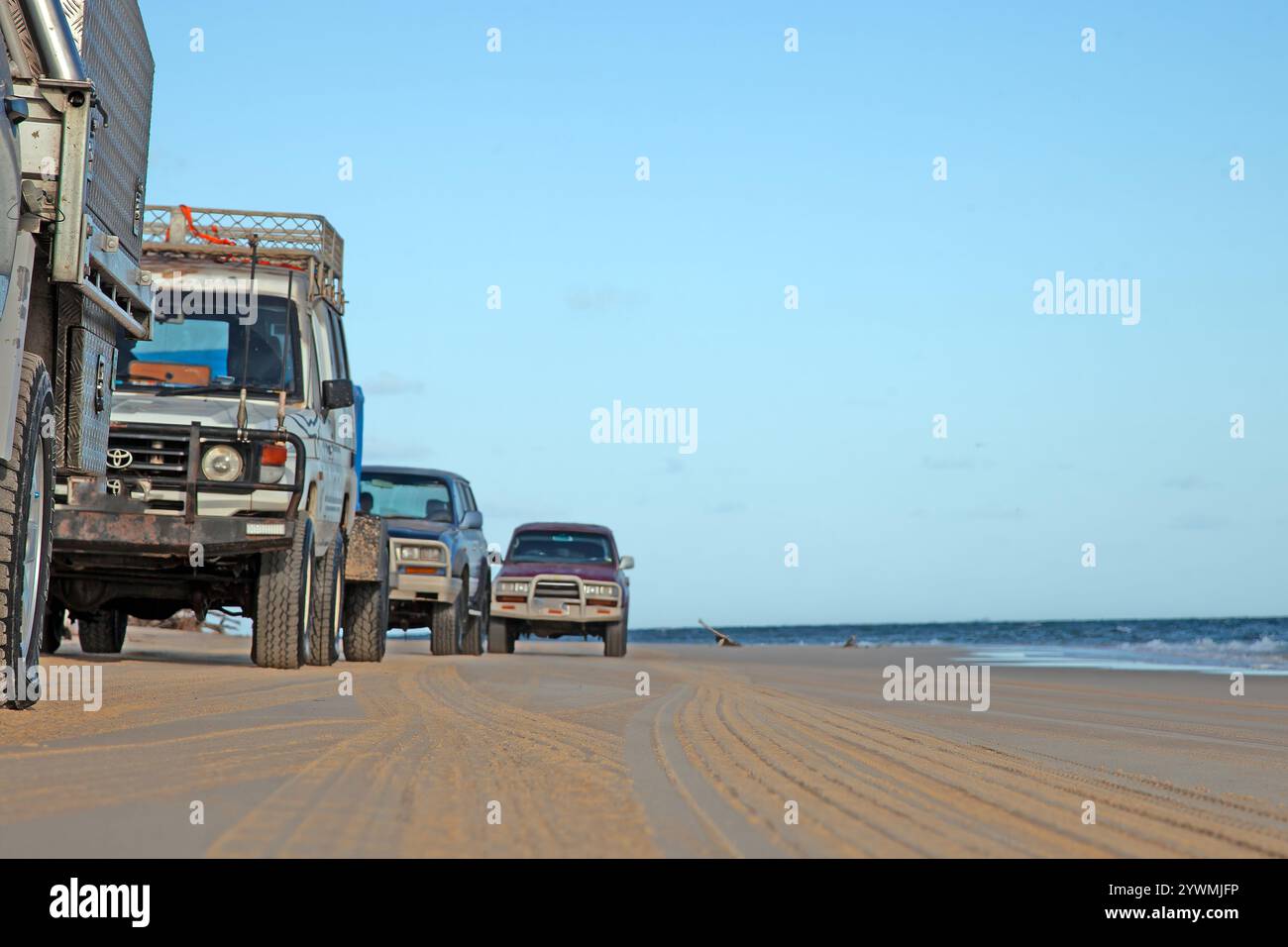 Off-road vehicles on Fraser Island beach with ocean waves and sandy ...