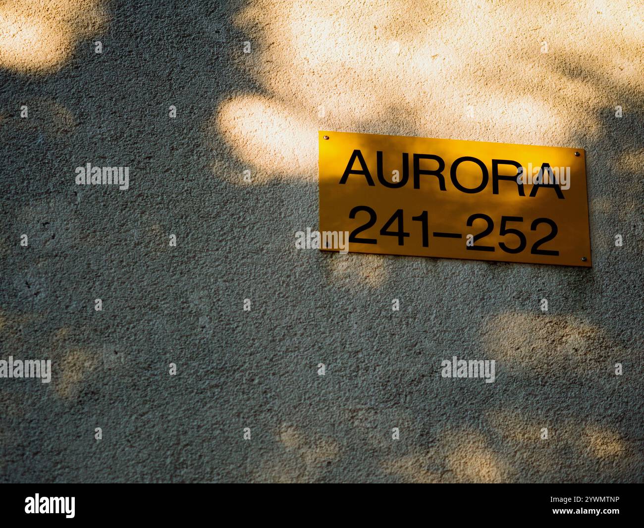 Golden plaque on plastered wall. Inscription Aurora and numbers 241-252 ...