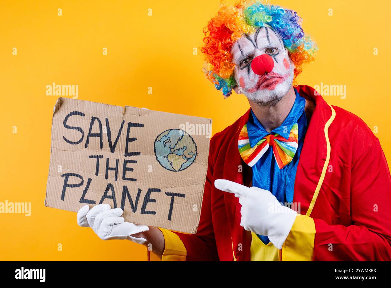 Smiling clown holding "Save the Planet" sign Stock Photo - Alamy