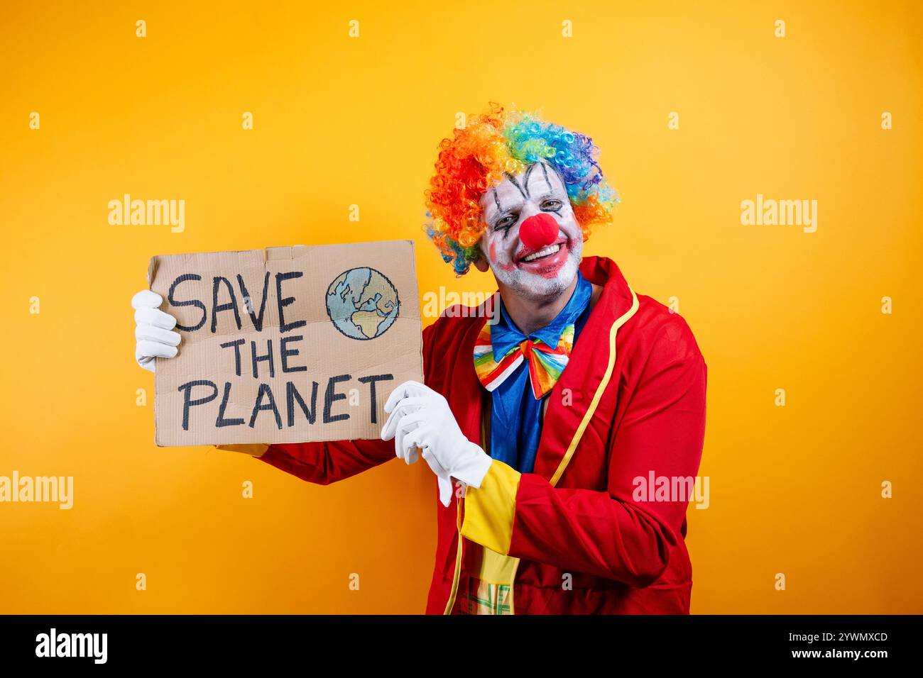 Smiling clown holding "Save the Planet" sign Stock Photo - Alamy