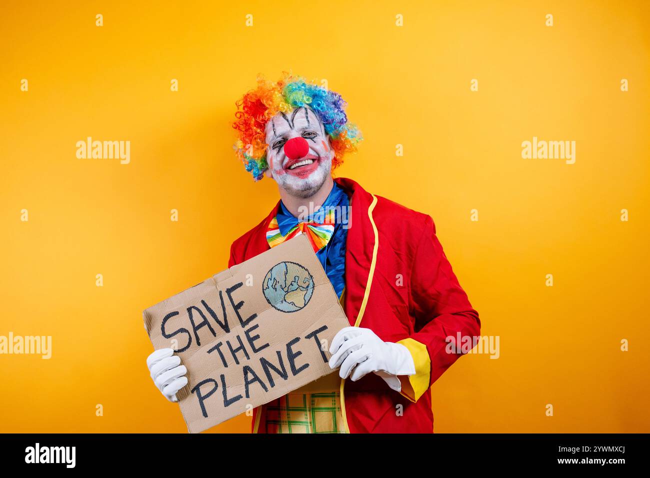 Smiling clown holding "Save the Planet" sign Stock Photo - Alamy