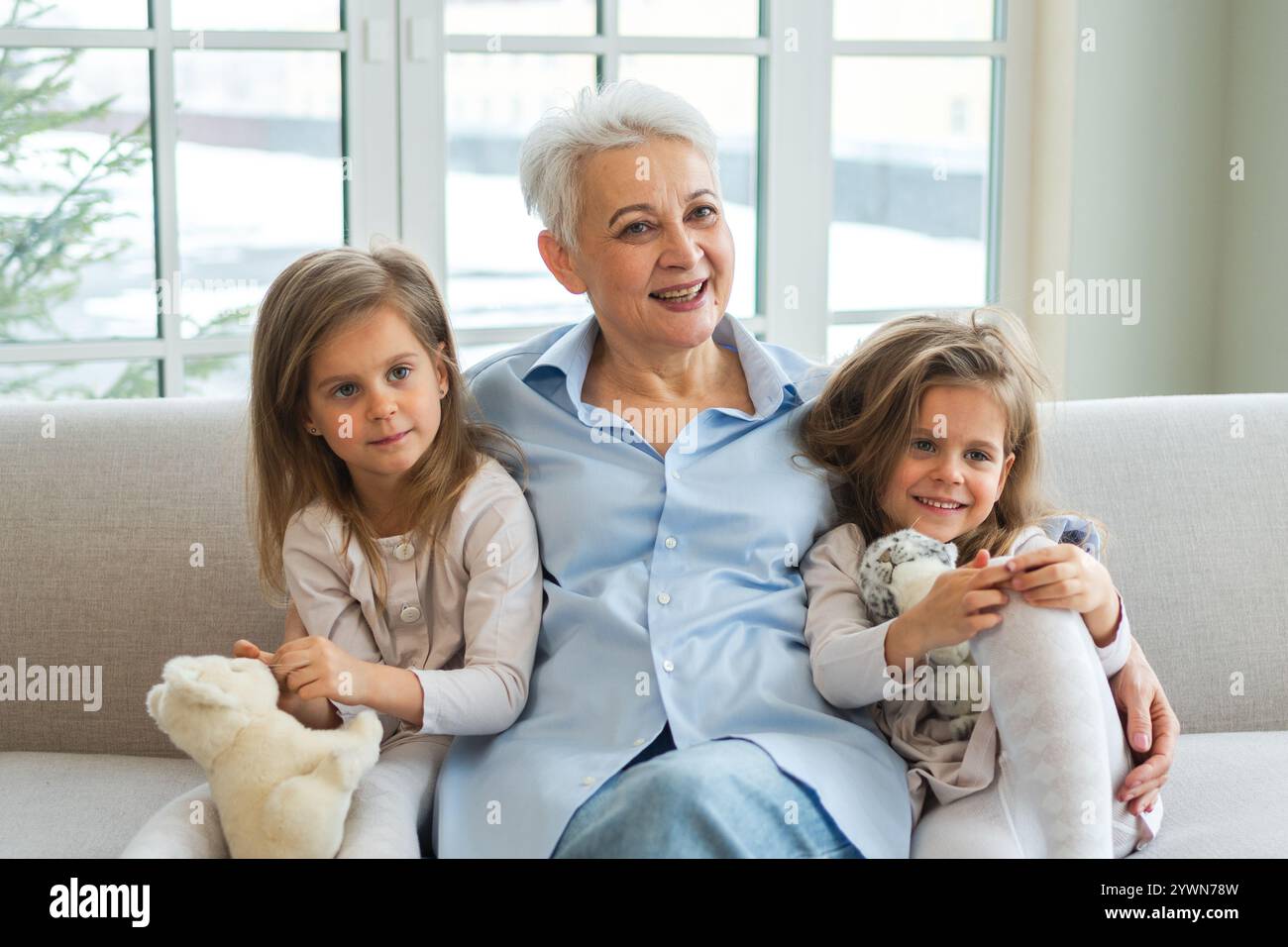 Happy family at home. Two little girls sisters twins grandmother ...