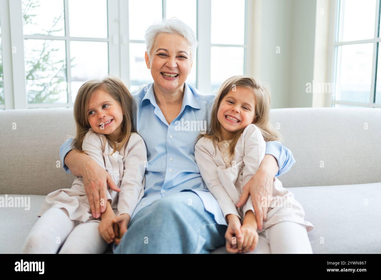 Happy family at home. Two little girls sisters twins grandmother ...