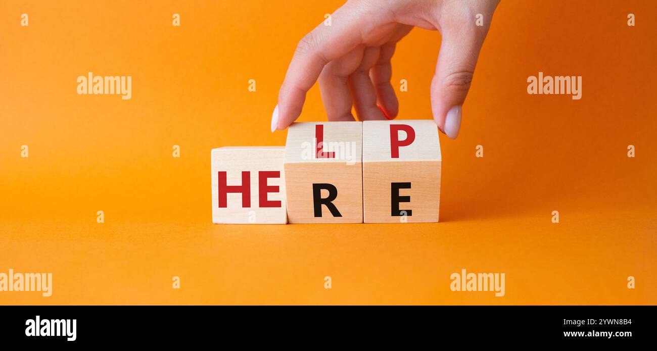Help is here symbol. Businessman hand Turns cube and changes word Here ...