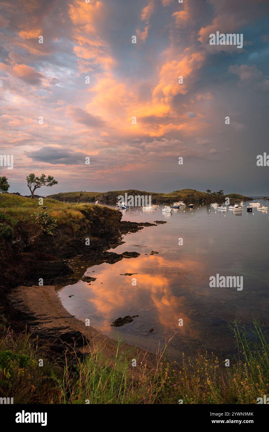 Boats anchored in the bay of Portlligat under a dramatic evening sky at ...