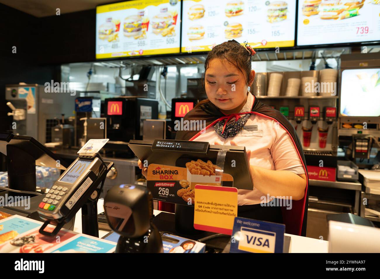 CHIANG MAI, THAILAND - OCTOBER 26, 2023: indoor portrait of a female cashier at McDonald's fast ...
