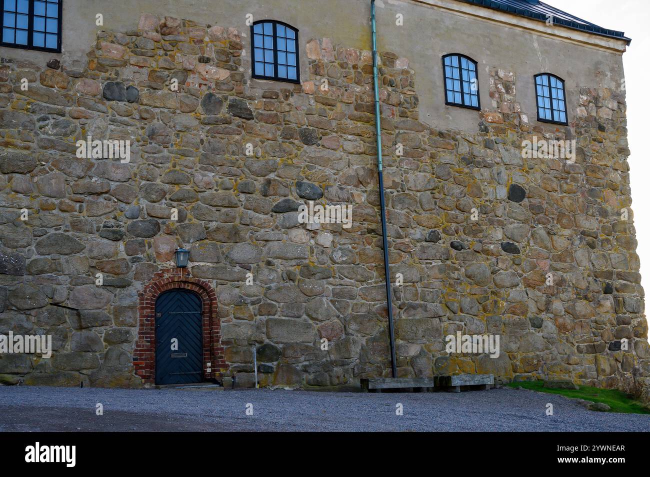 A sturdy stone wall features large, irregular stones and several ...