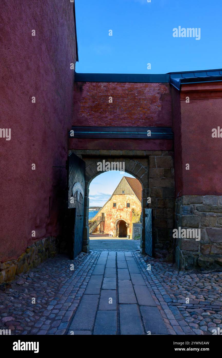 An archway frames a charming structure in the distance, surrounded by a ...