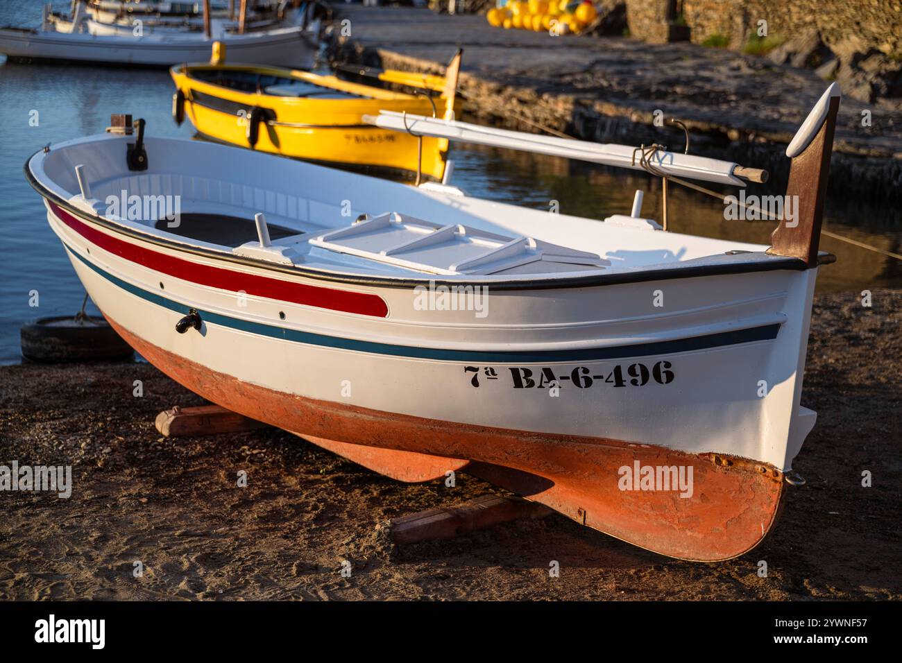 A traditional wooden boat lies on the beach in the bay of Portlligat in ...