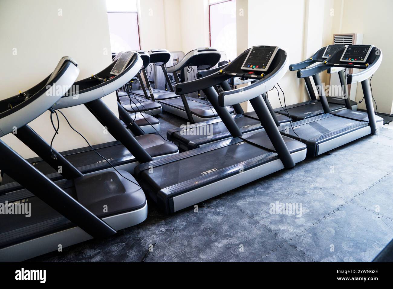 Modern gym interior with equipment. Fitness club with row of treadmills ...