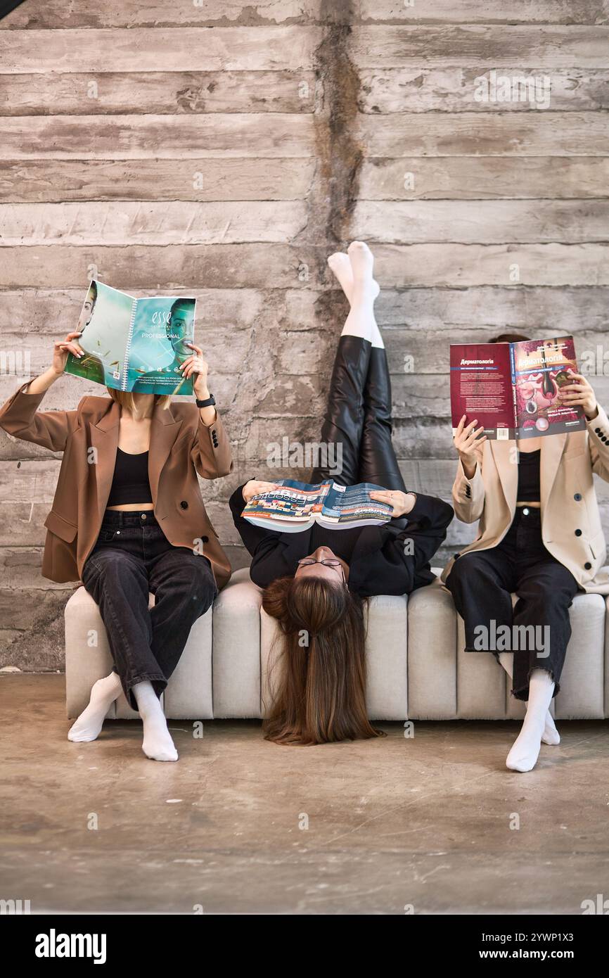 Three Women Reading Magazines on Bench Stock Photo - Alamy