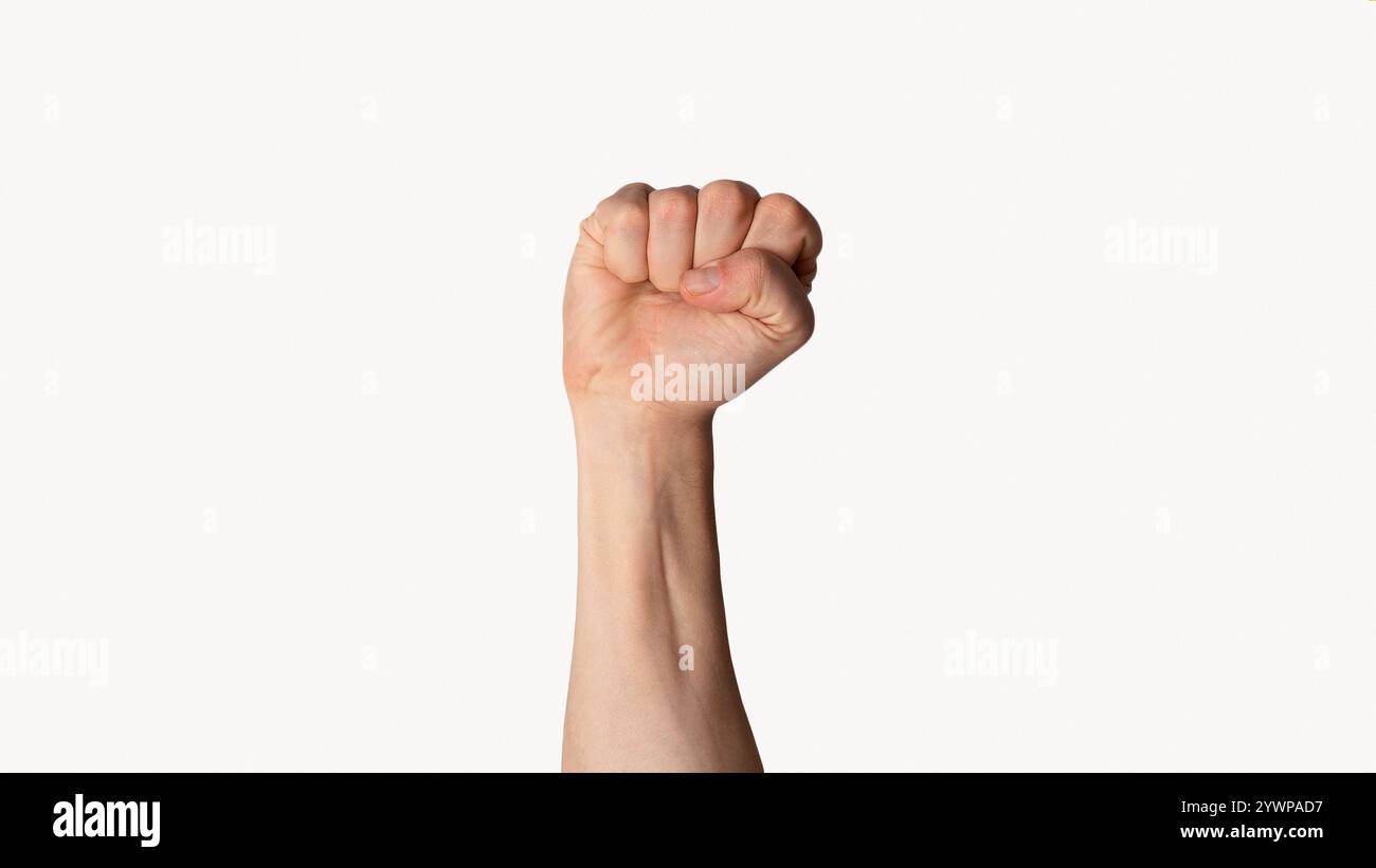 Millennial man raising his clenched fist up over light background ...