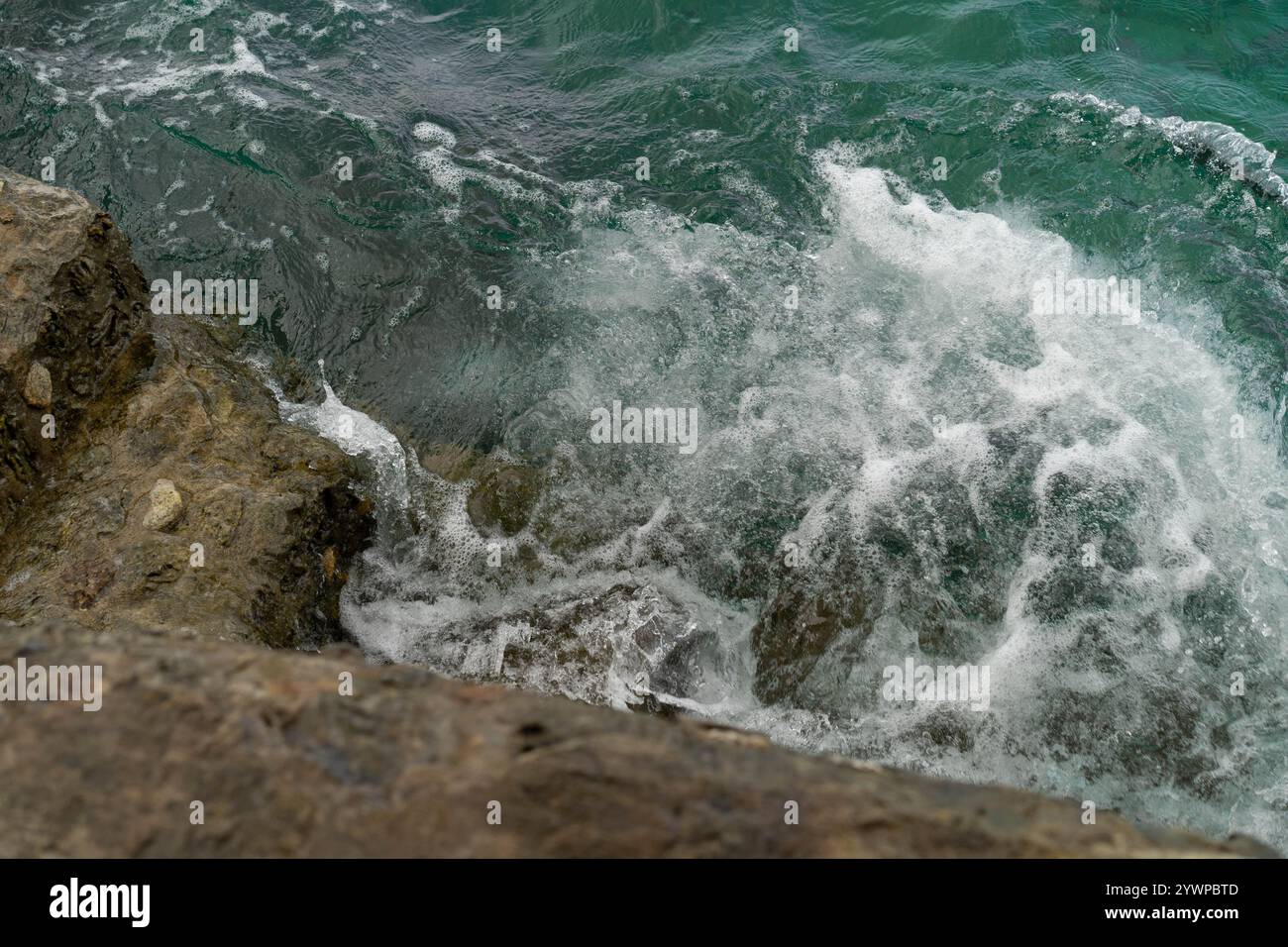 Surf waves collide with the rugged coastline, creating a beautiful ...