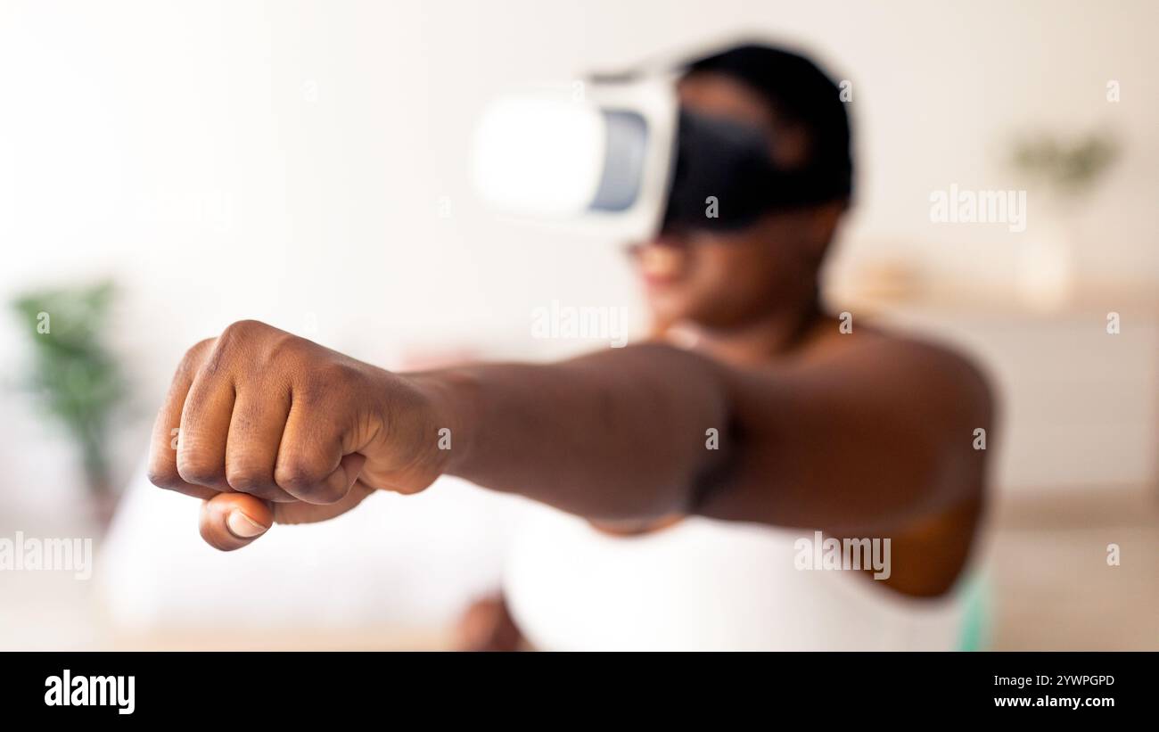 Virtual training. Overweight black lady in VR glasses using fighting ...