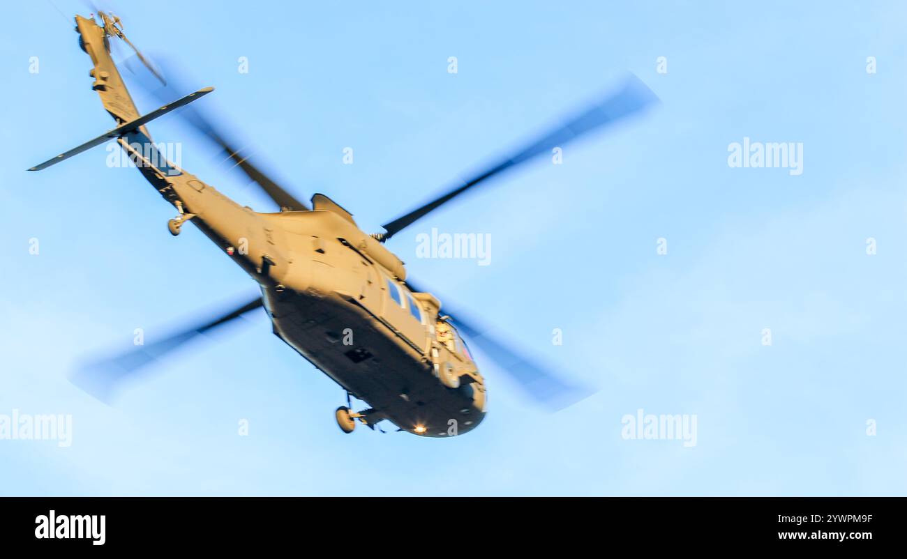 Military helicopter performs an impressive flight maneuver against a ...