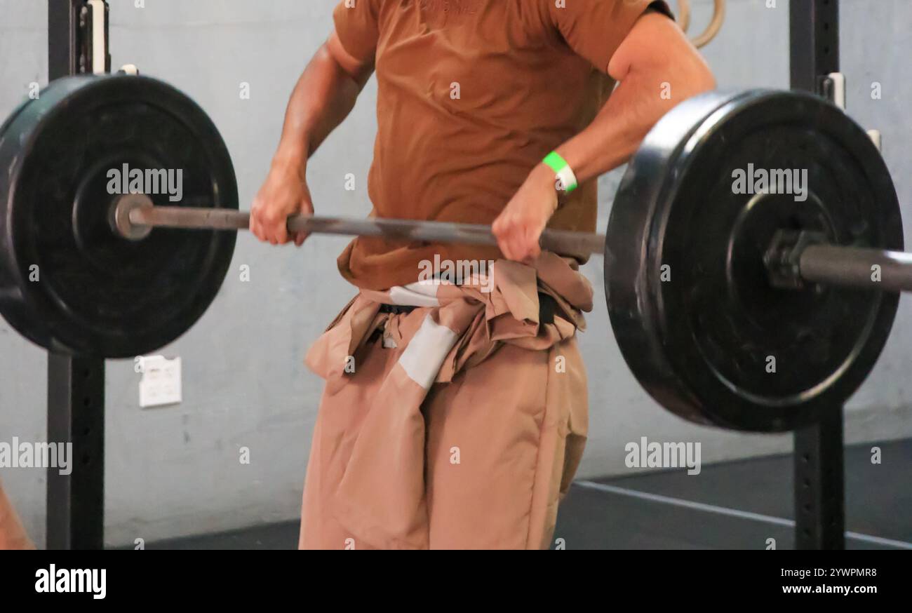 A dedicated athlete lifts a heavy barbell in a gym, showcasing strength ...