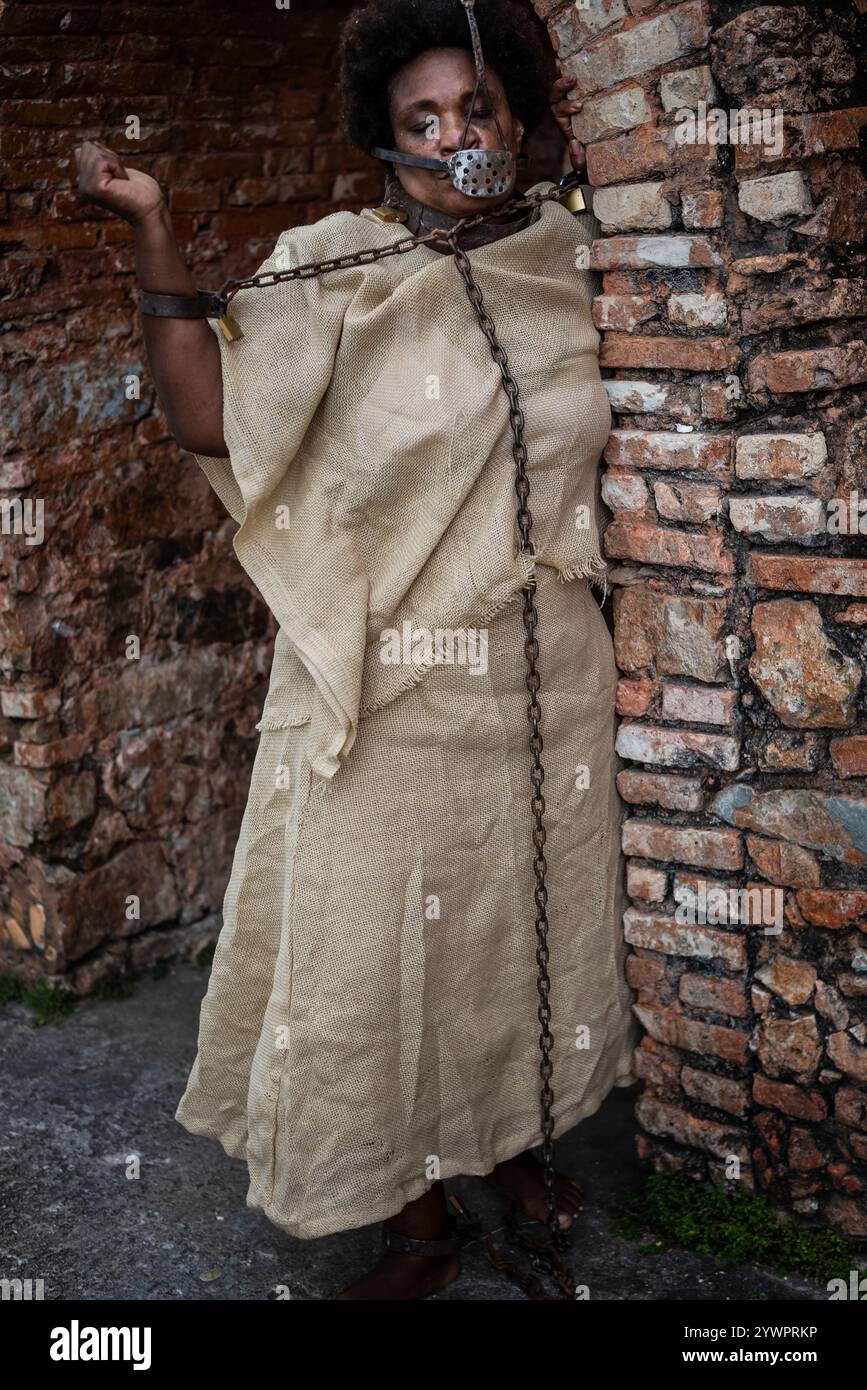 Portrait of a black woman dressed as a slave, chained with an iron mask ...