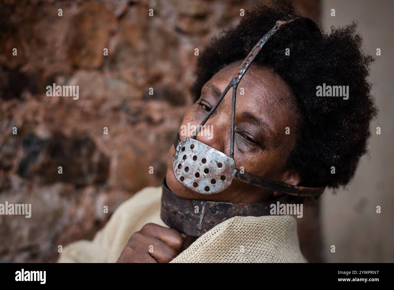 Portrait of a black woman's face with an iron mask stuck in her mouth ...