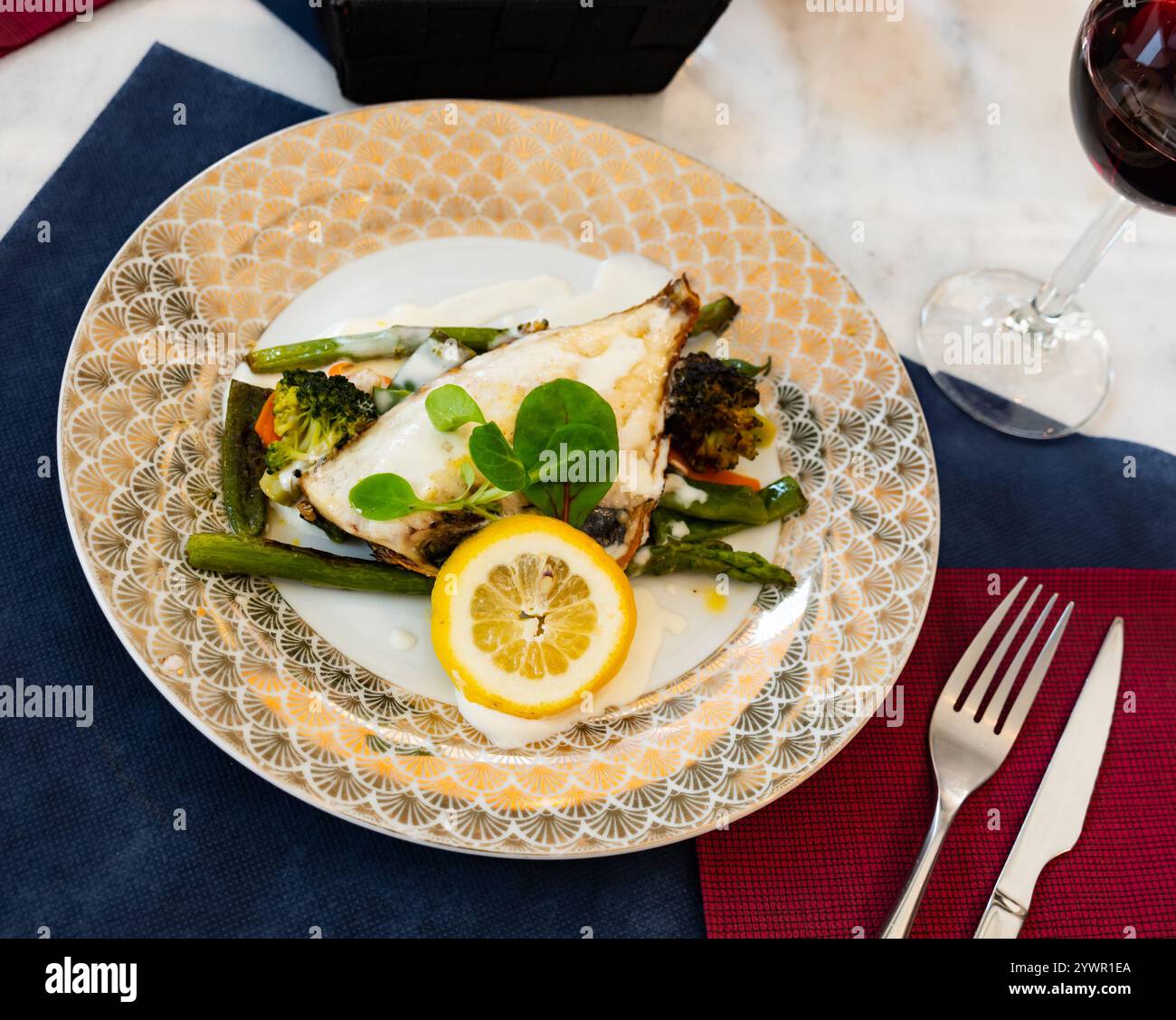 Grilled fillet of dorada with lemon, vegetables and white sauce Stock ...