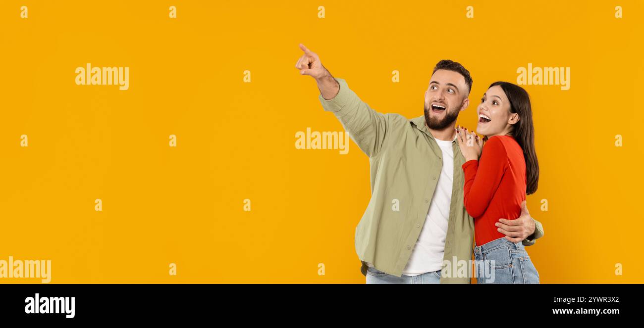 Couple sharing a joyful moment while pointing at something together ...