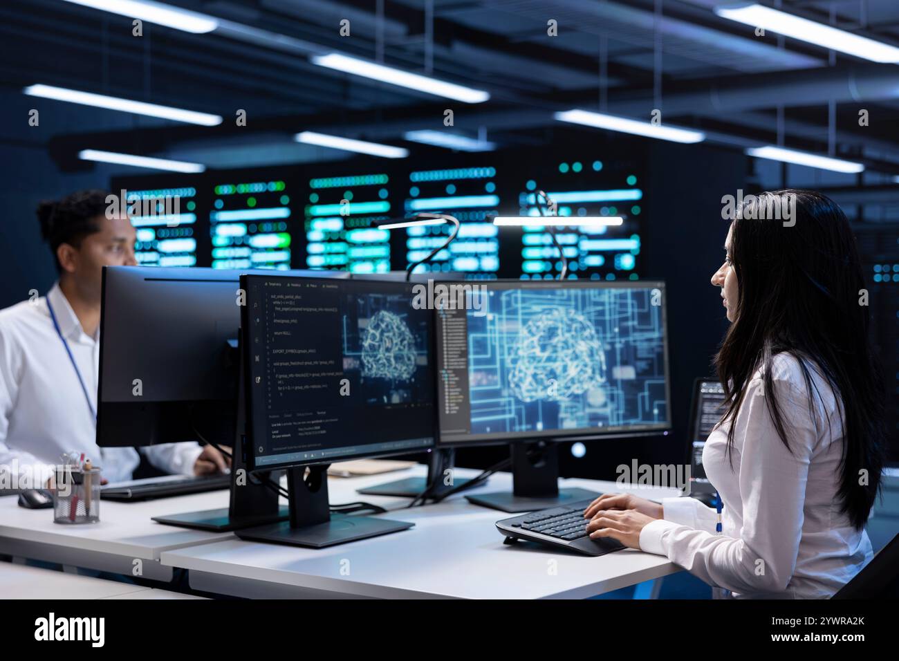 Team of specialists working on PC in data center with artificial intelligence tech to process ...