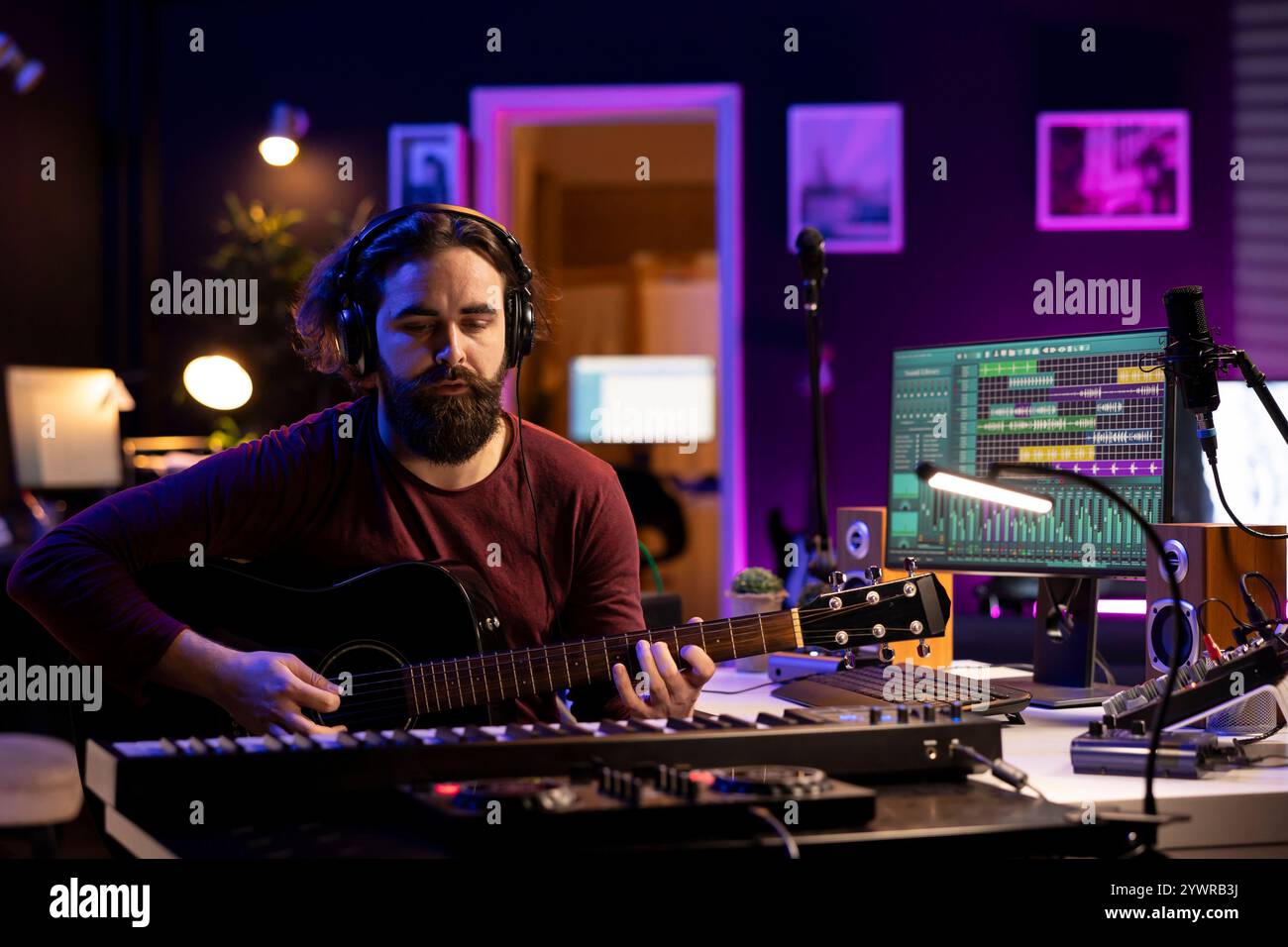 Music engineer recording songs and playing acoustic guitar, working in ...