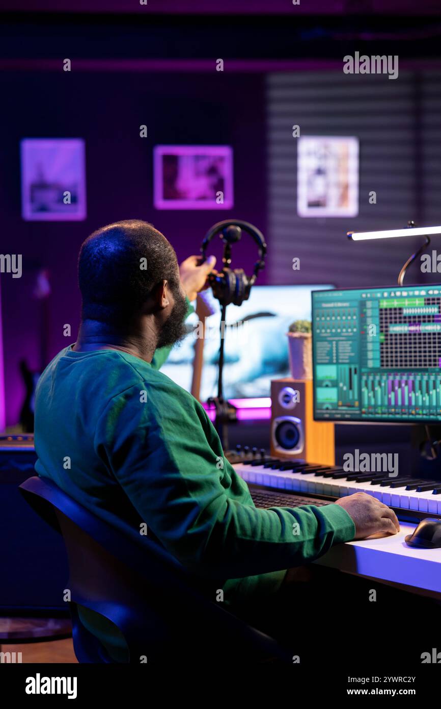 Sound producer working with console and electronic keyboard to create ...