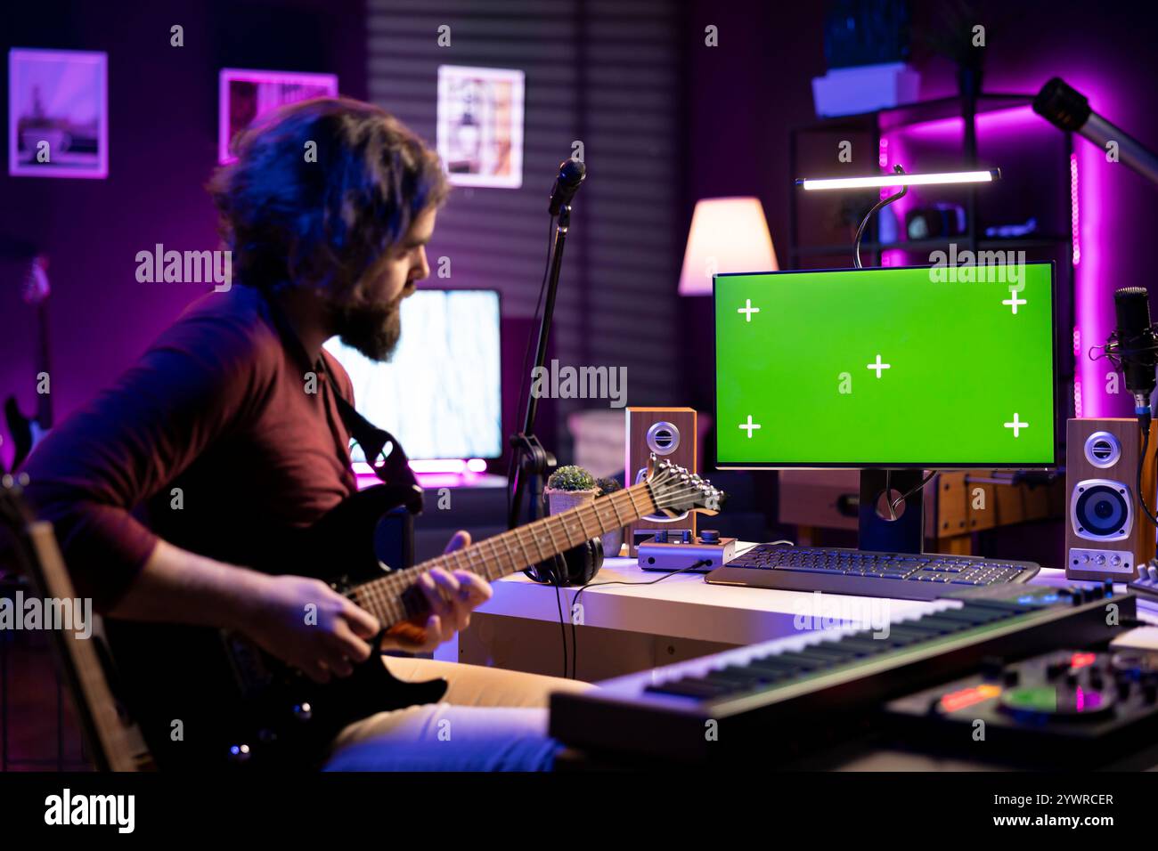 Artist playing acoustic guitar and following tutorials online on ...
