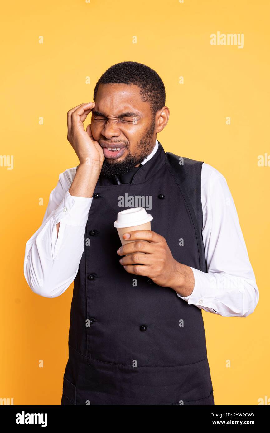 Restaurant worker suffering from a painful migraine while he serves ...