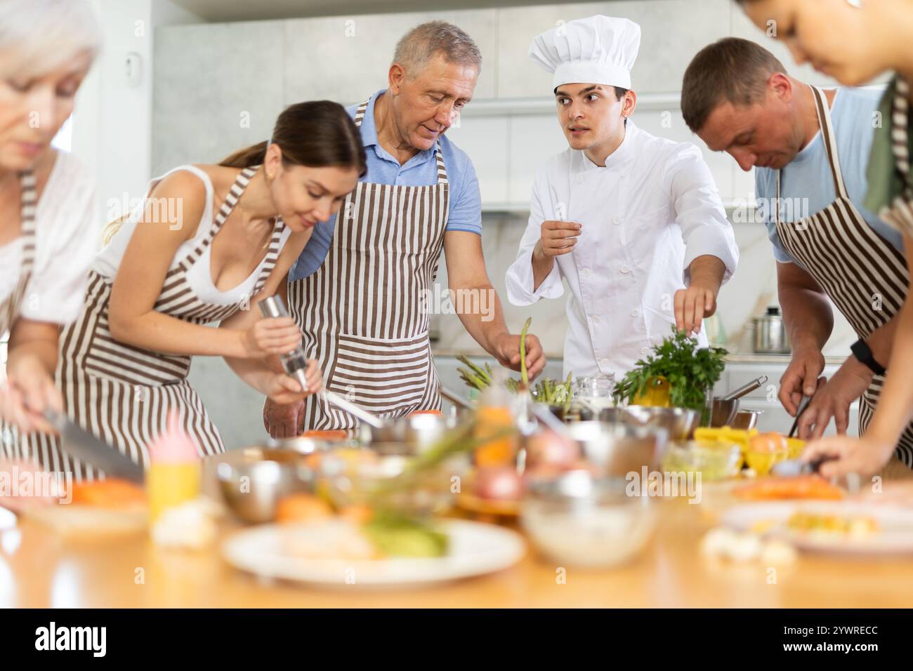 Young guy cook teaches to cook group of people Stock Photo - Alamy