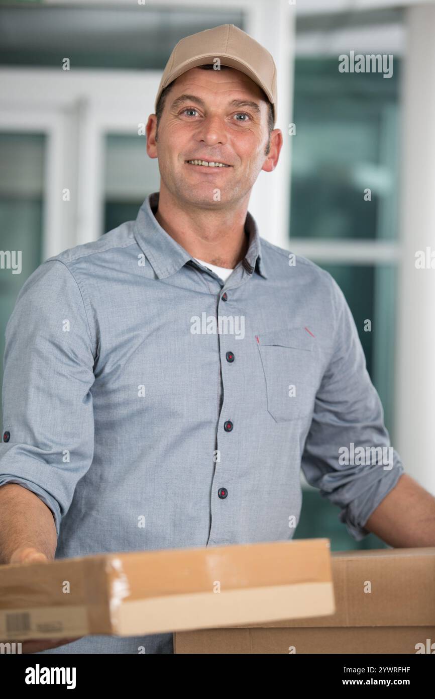 delivery man giving a cardboard box Stock Photo - Alamy