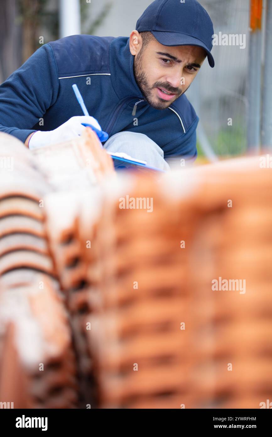 construction worker counting the bricks Stock Photo - Alamy