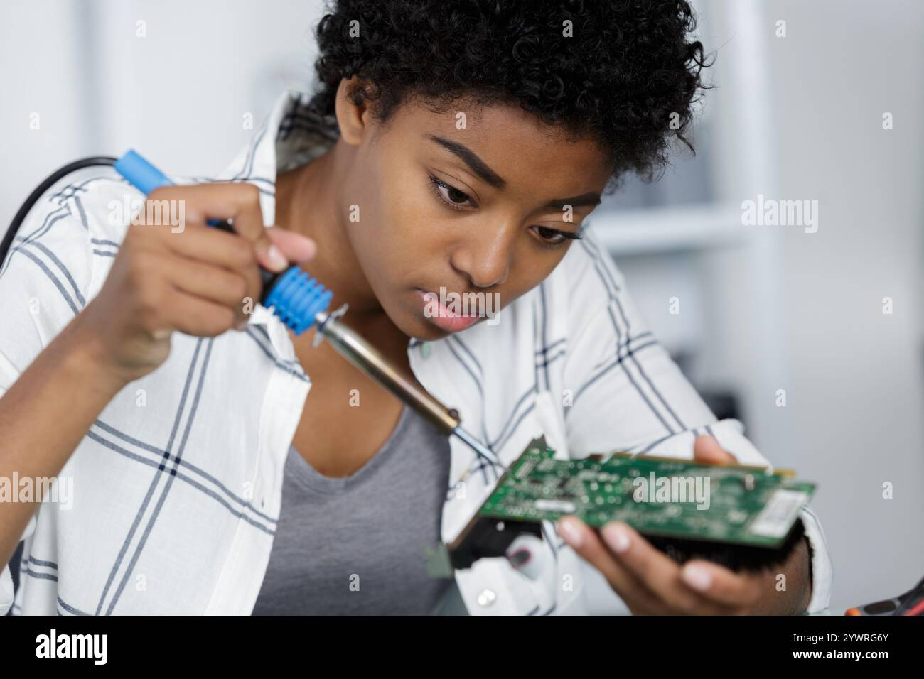 woman soldering elements of circuit board Stock Photo - Alamy