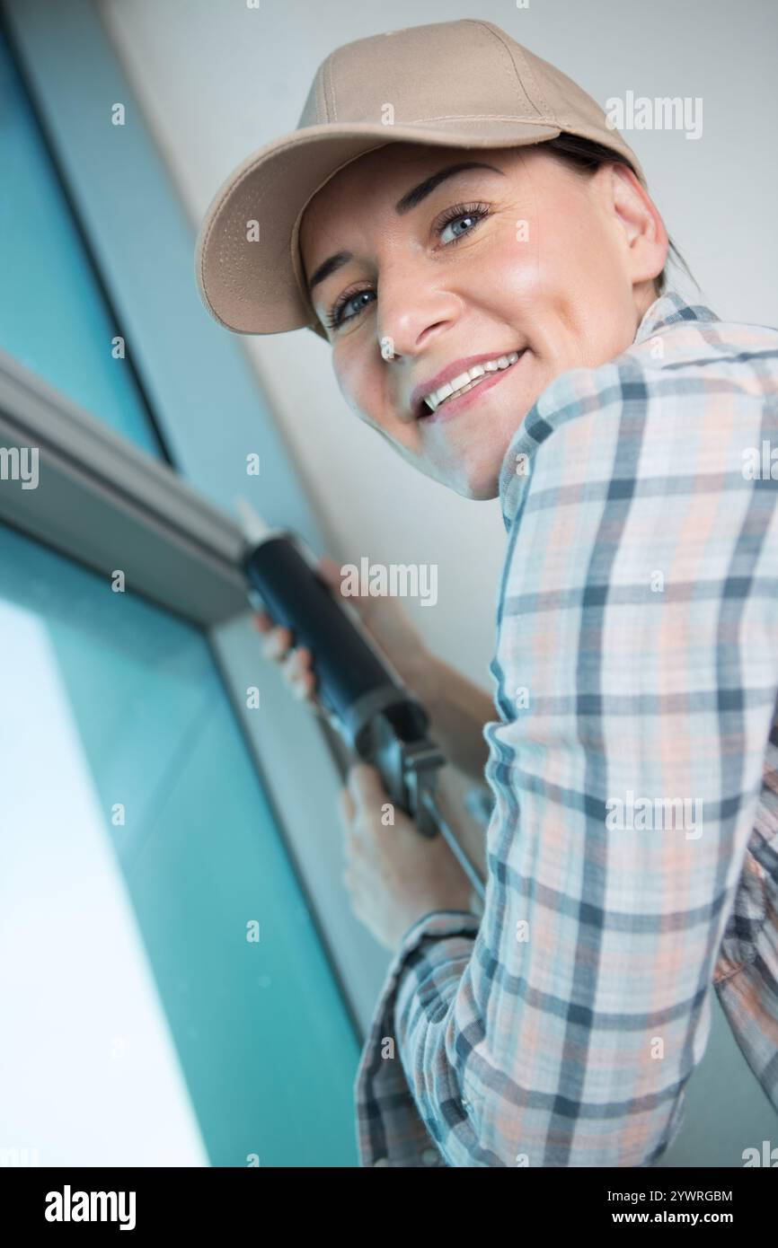 woman window installer applying caulking Stock Photo - Alamy